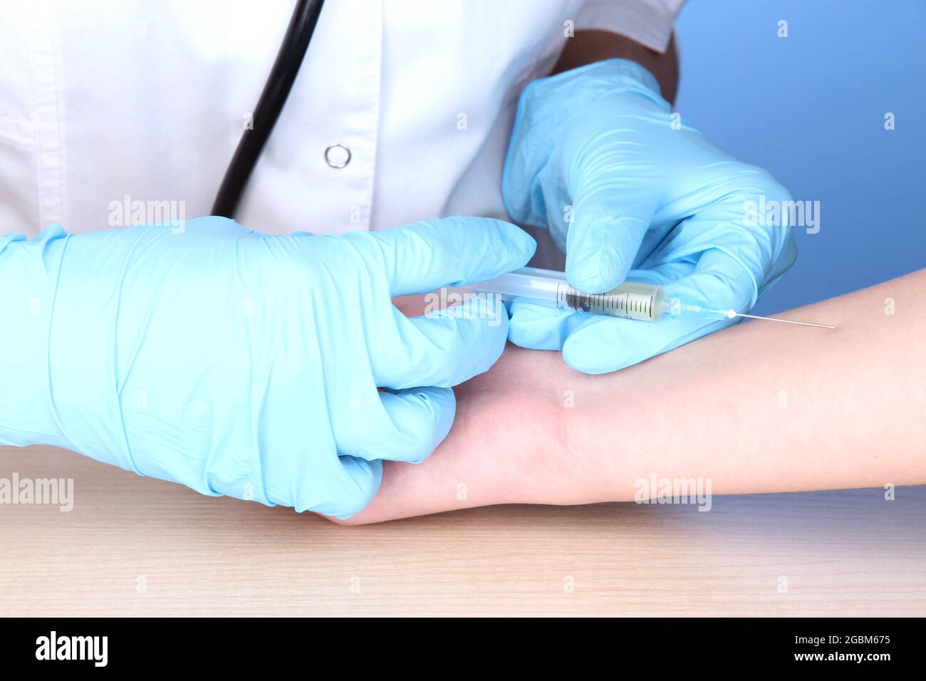 vaccine injection in hand on blue background Stock Photo - Alamy