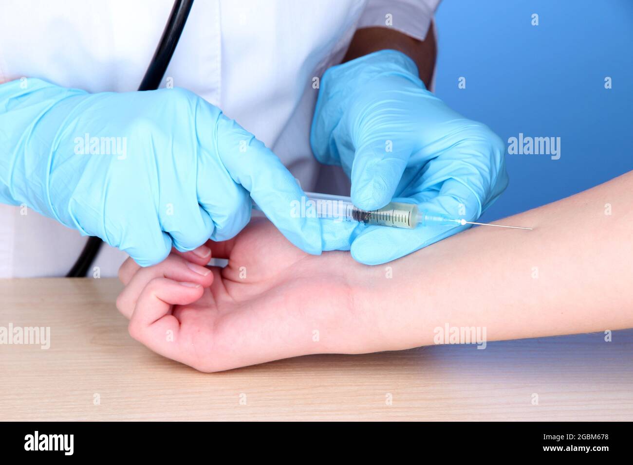 vaccine injection in hand on blue background Stock Photo - Alamy