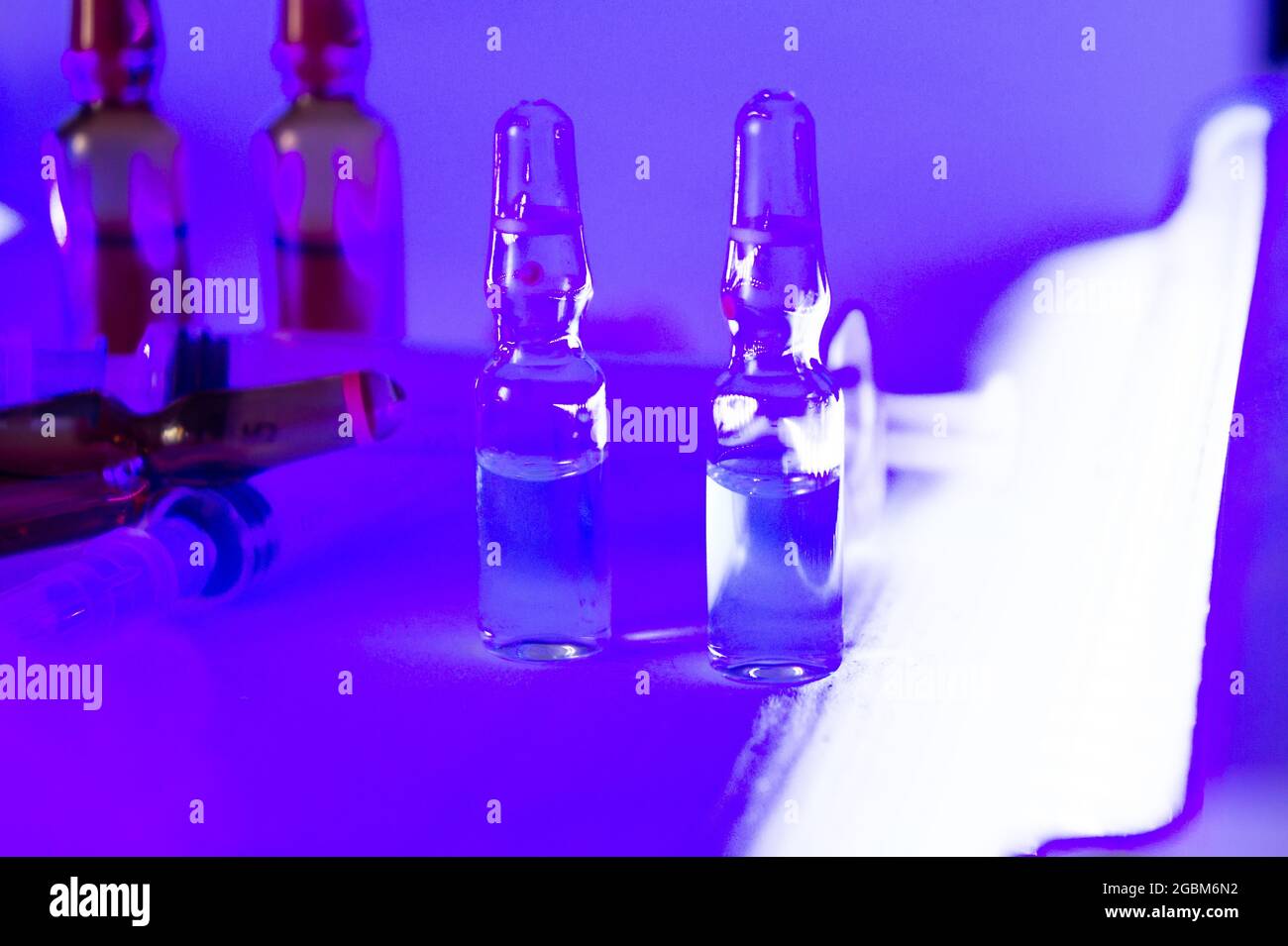 Ampoules on a purple surface in a dark room Stock Photo - Alamy