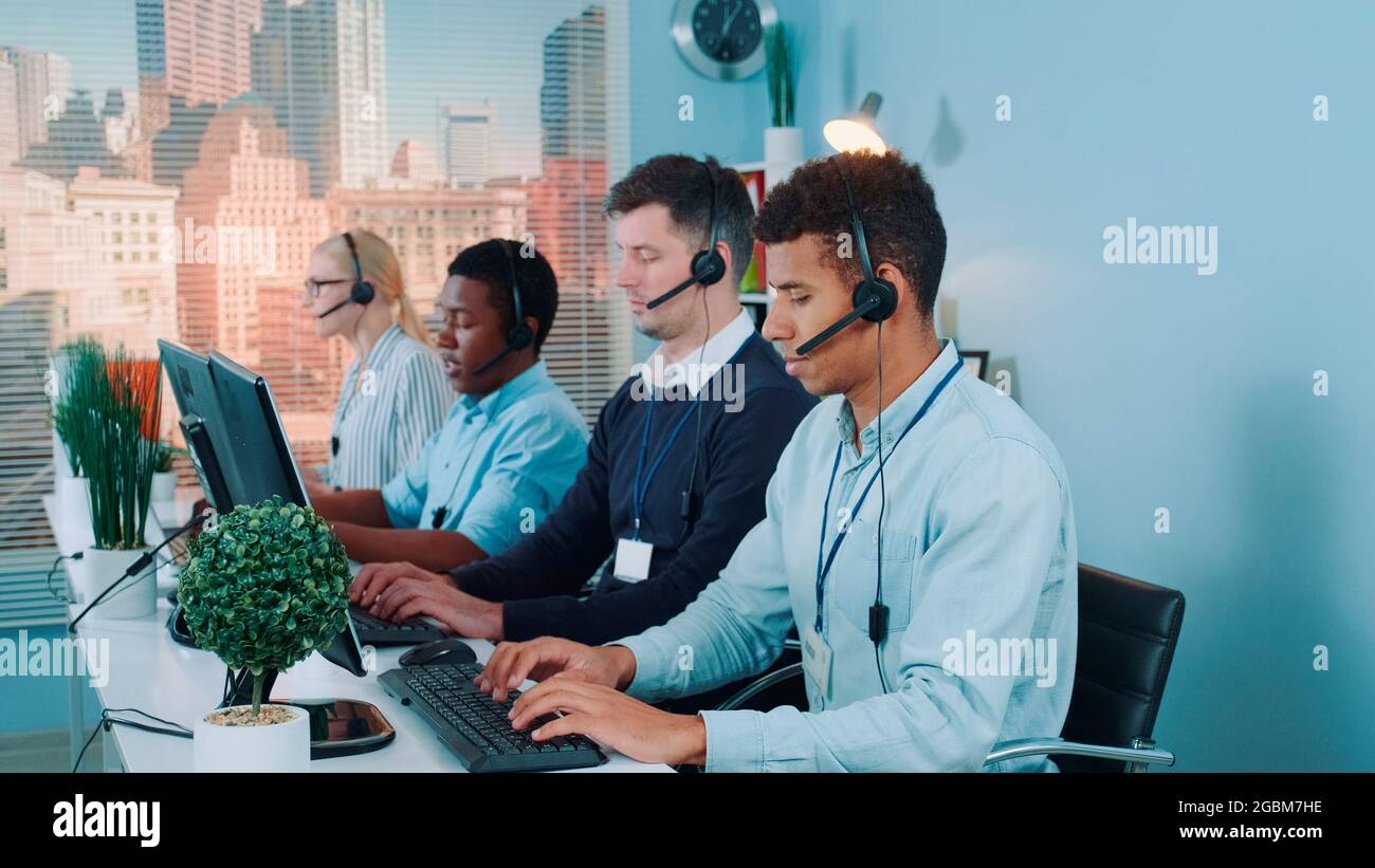 Multiracial call center agents talking to the clients in headset. There ...