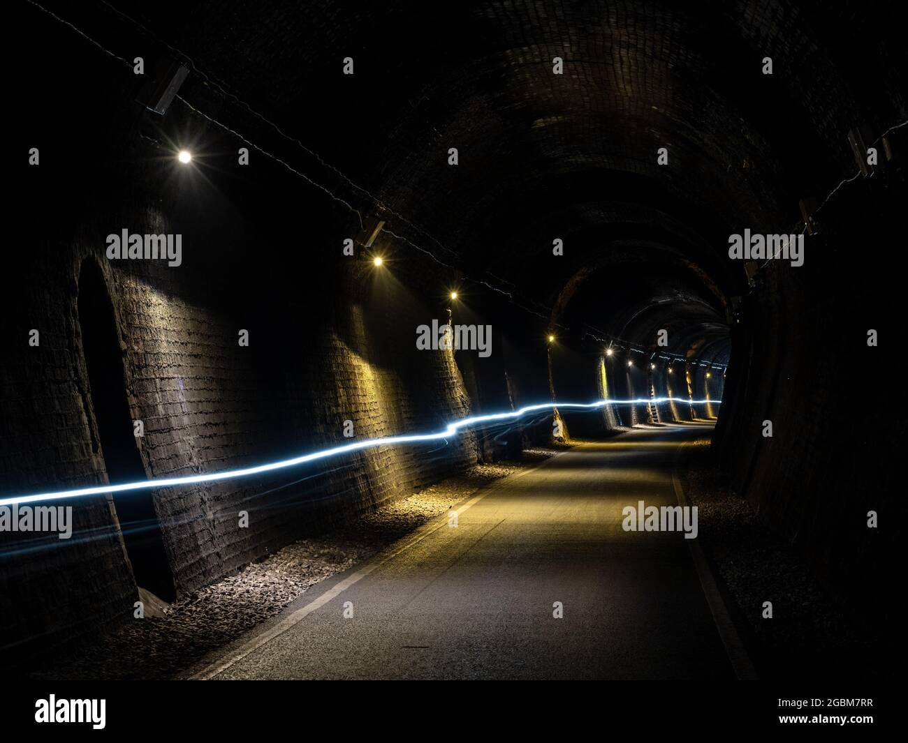 A cyclist's headlight shines in the dark Combe Down Tunnel, part of the ...