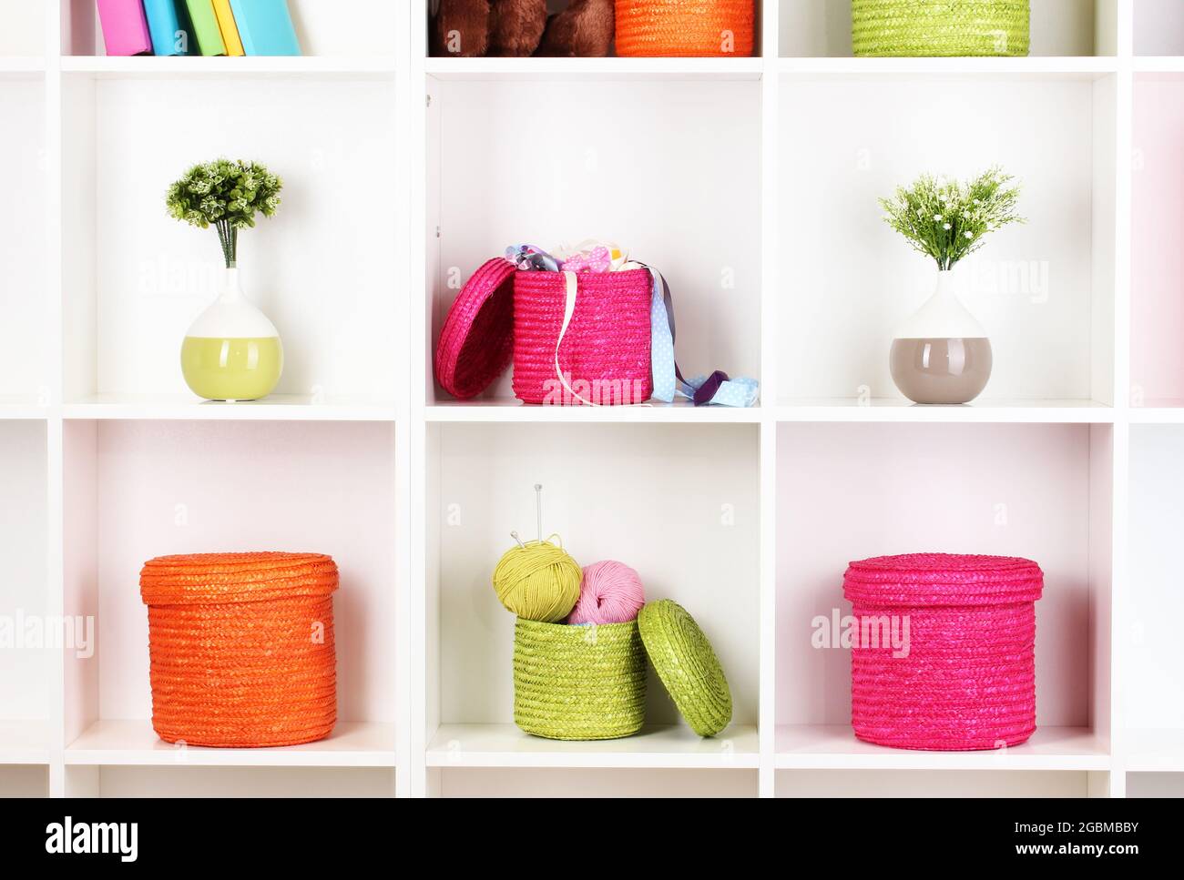 Color wicker boxes on cabinet shelves Stock Photo - Alamy