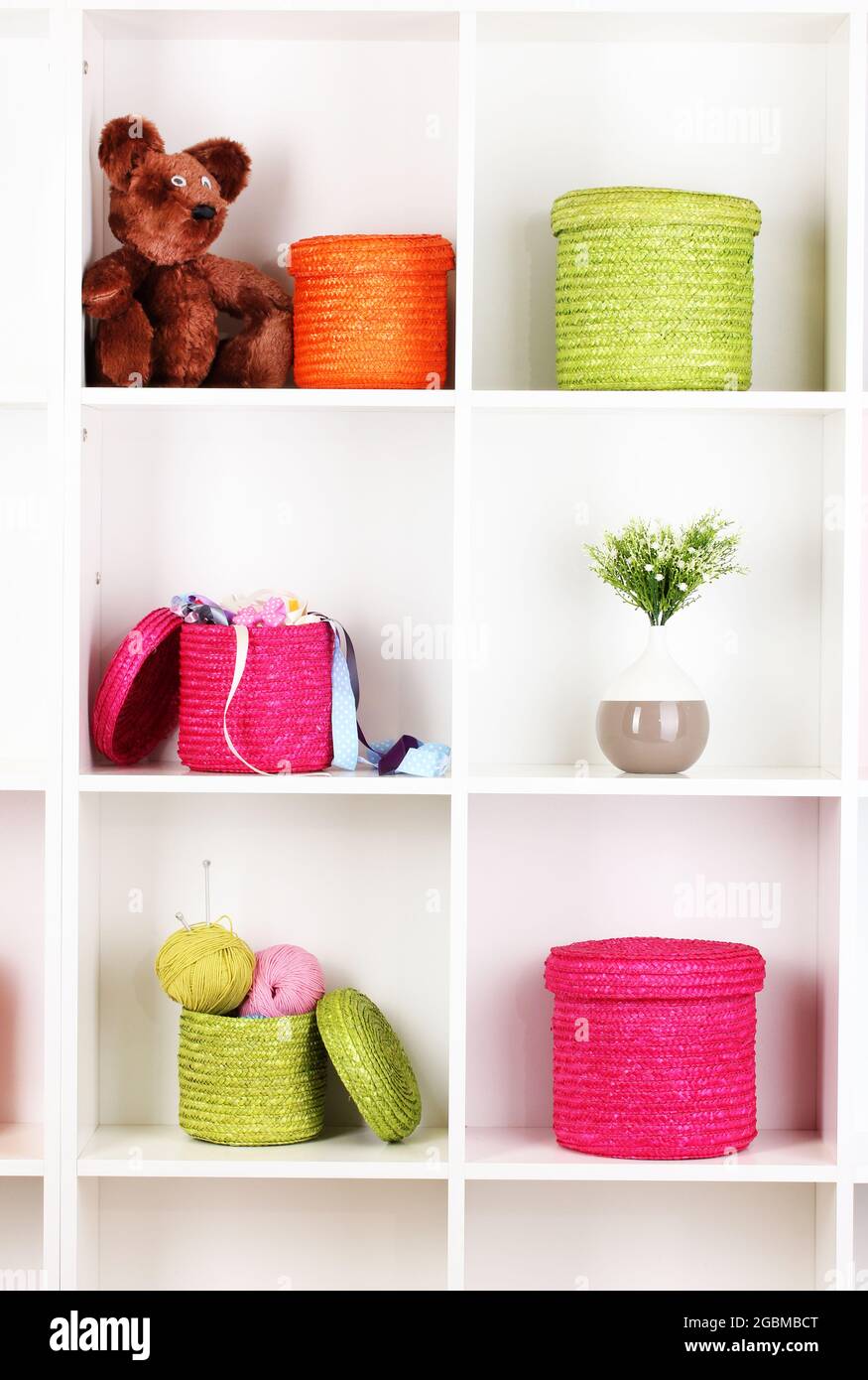 Color wicker boxes on cabinet shelves Stock Photo - Alamy