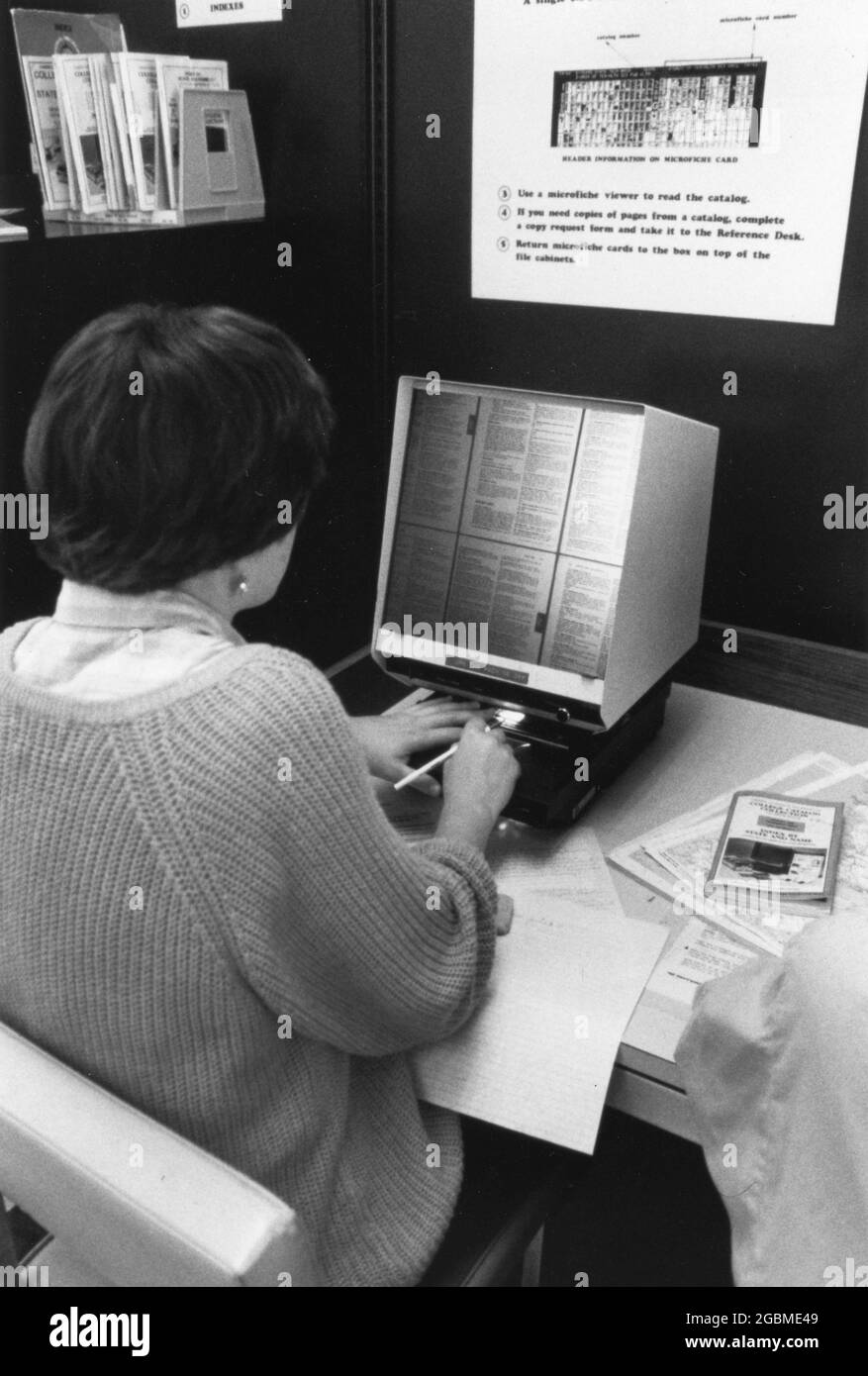 Austin Texas USA, circa 1992: Female college student using microfiche ...