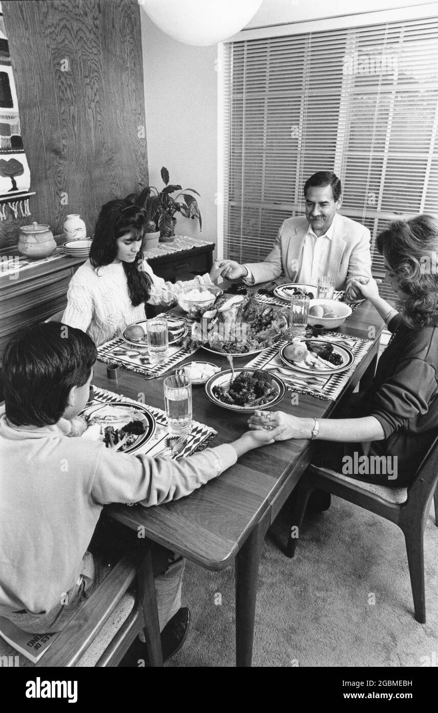 Austin Texas USA, 1990: Hispanic family holds hands and prays together ...