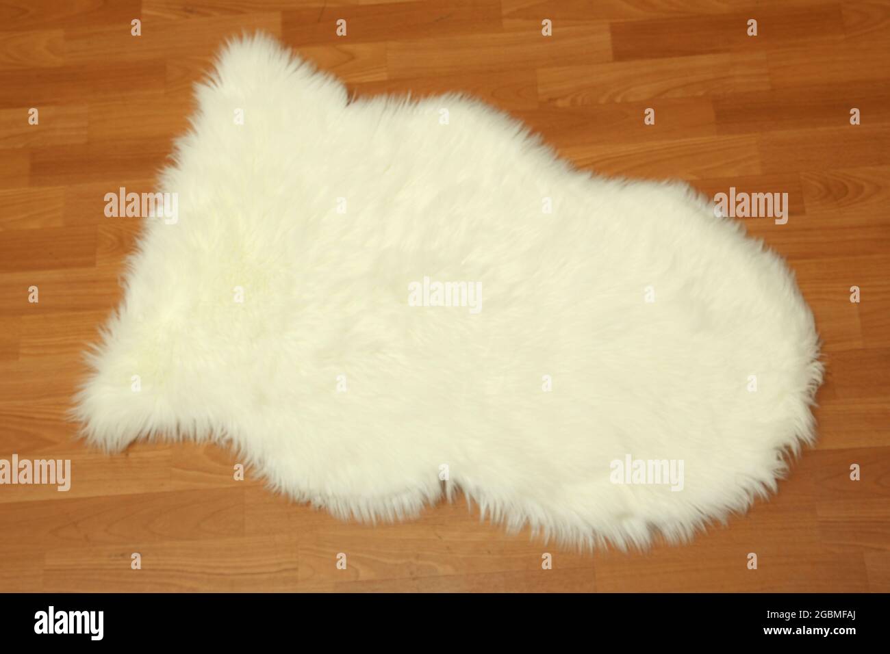 Decorative fur carpet on wooden floor Stock Photo - Alamy