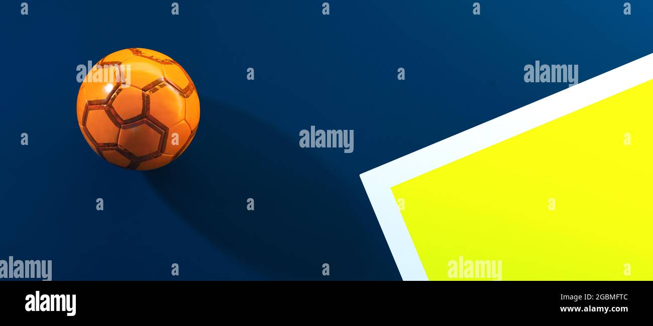Orange futsal soccer ball laying on the blue indoor soccer field ...
