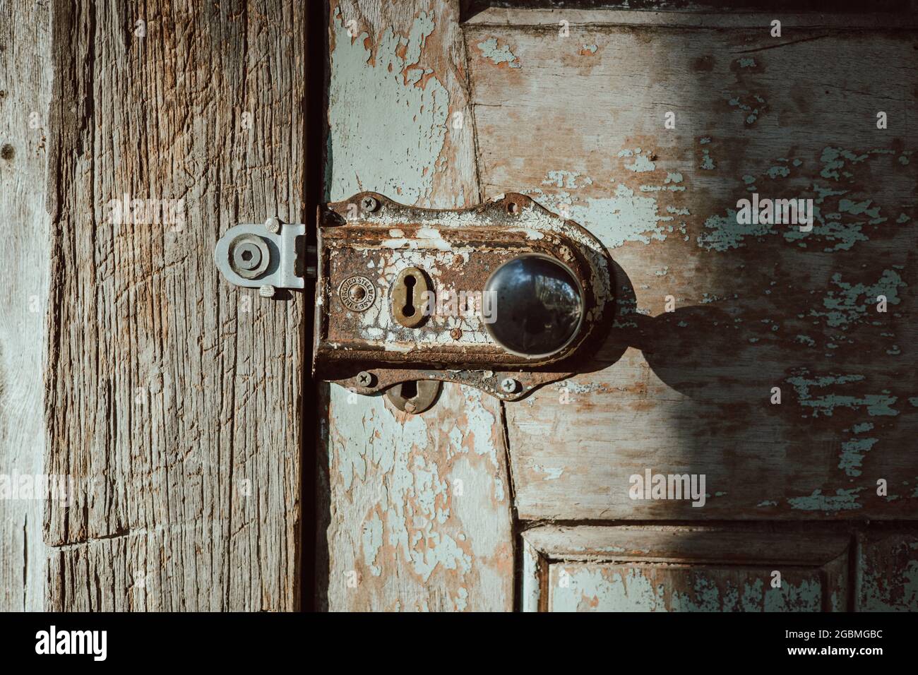 Closeup shot of an old rusty knob on a weathered wooden door Stock ...