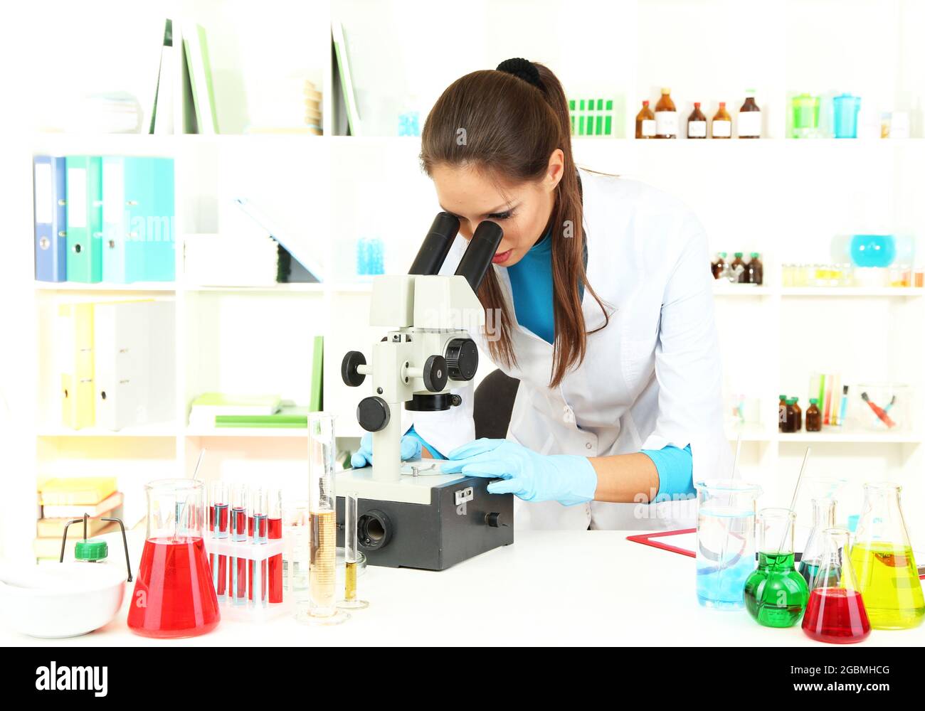 Young scientist looking into microscope in laboratory Stock Photo - Alamy
