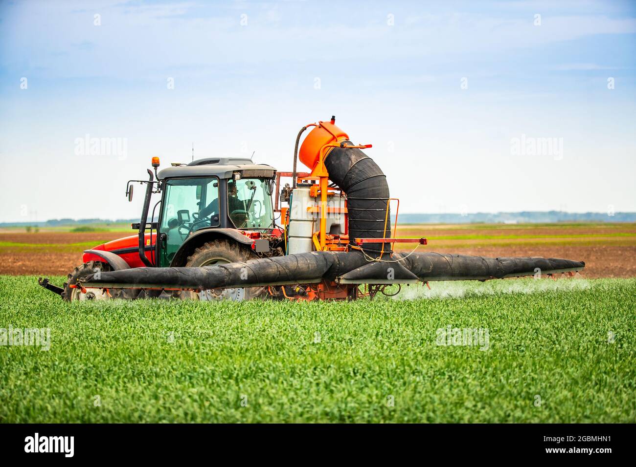 Farmer spraying wheat crops at field Stock Photo - Alamy
