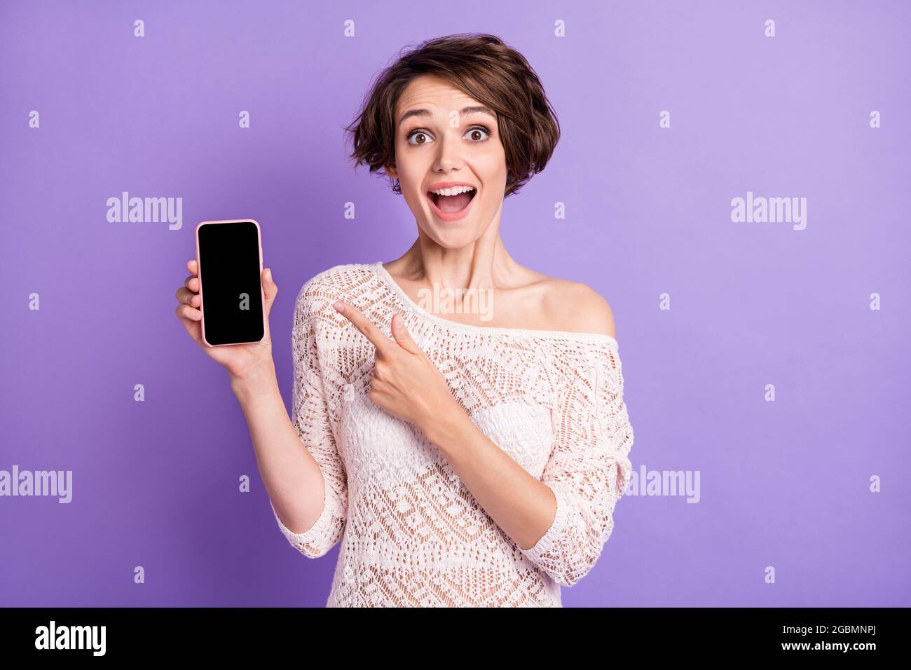 Photo of cute impressed young woman wear knitted shirt pointing finger ...