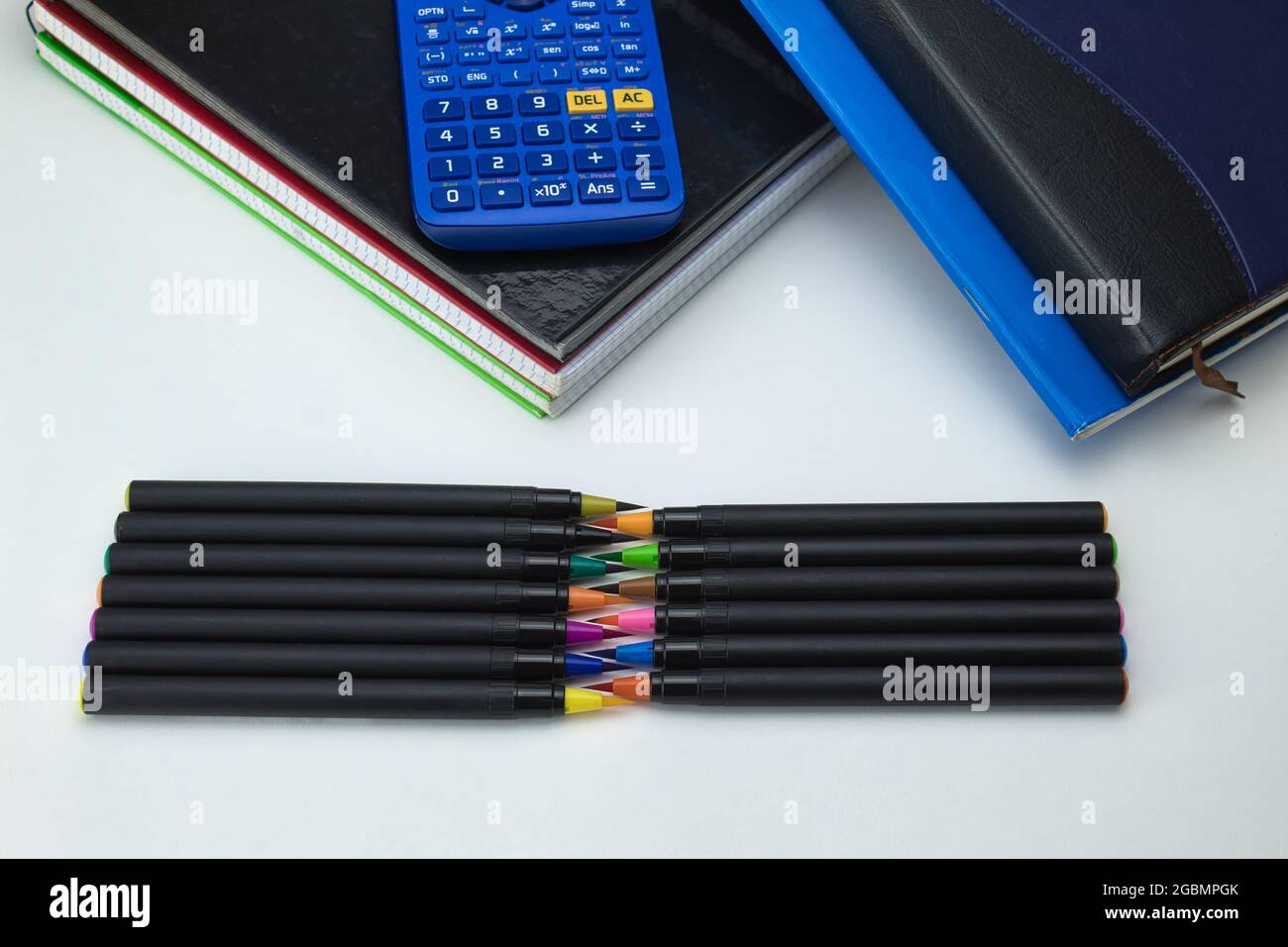 group of school tools with notebooks, markers, pens, clips, calculator ...