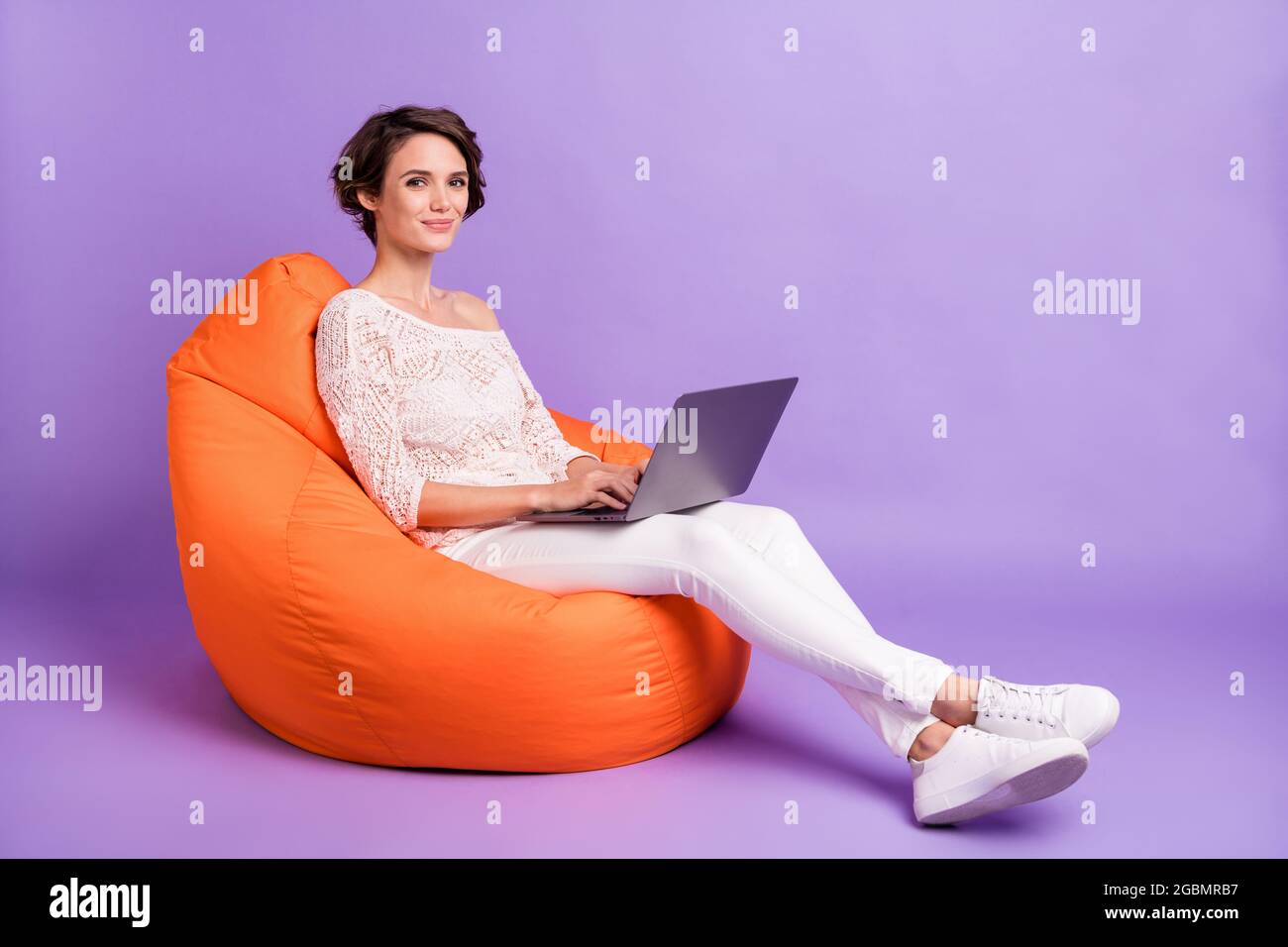 Photo of sweet charming young woman wear knitted shirt sitting beanbag ...
