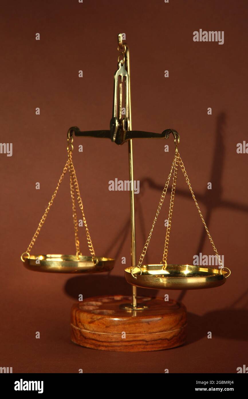 Gold scales of justice on brown background Stock Photo - Alamy