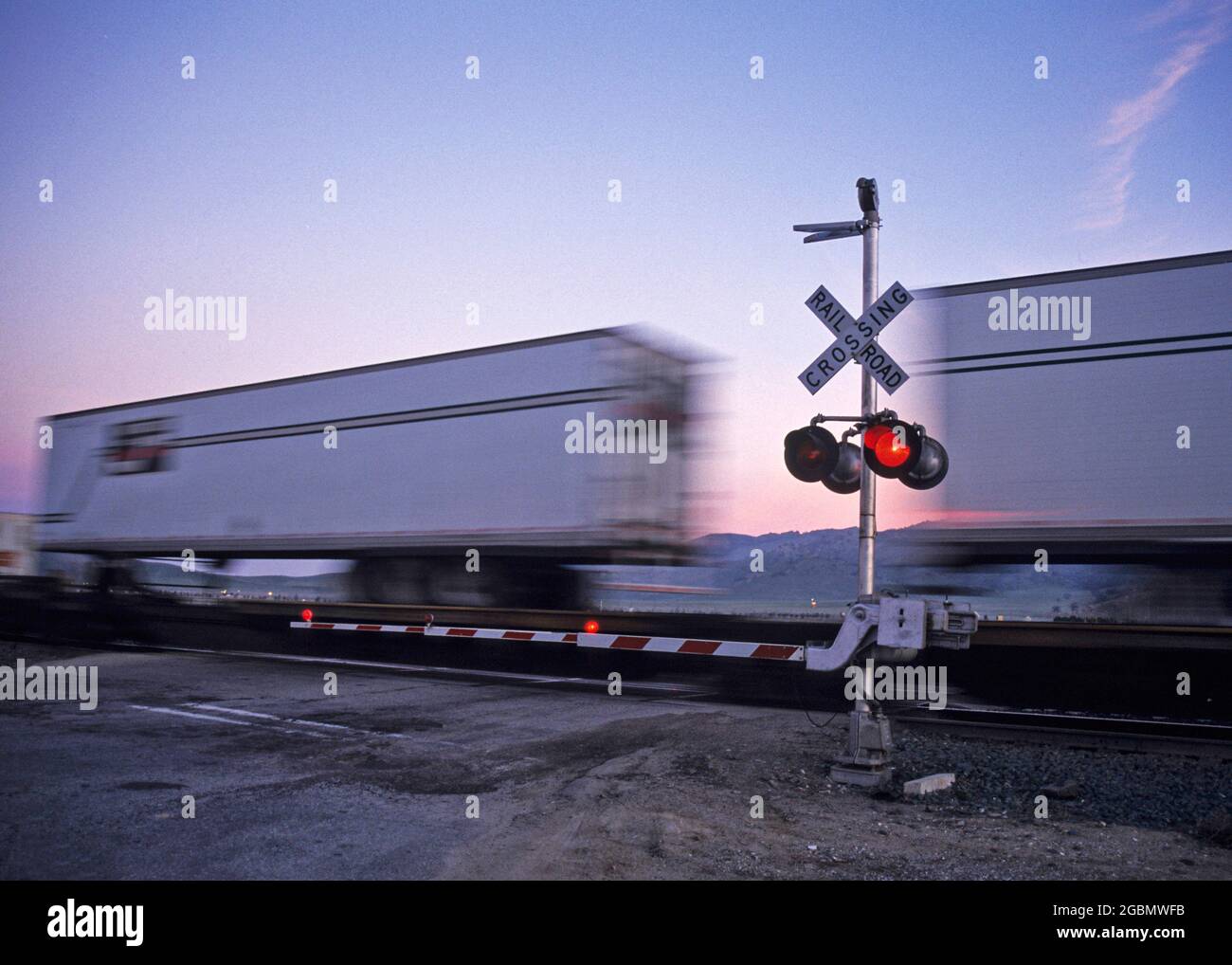 Freight train moves past a crossing in Tehachapi, California Stock ...