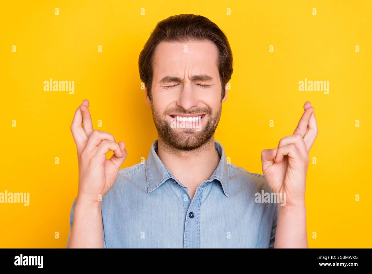 Photo portrait of young man hope for luck with crossed fingers isolated ...