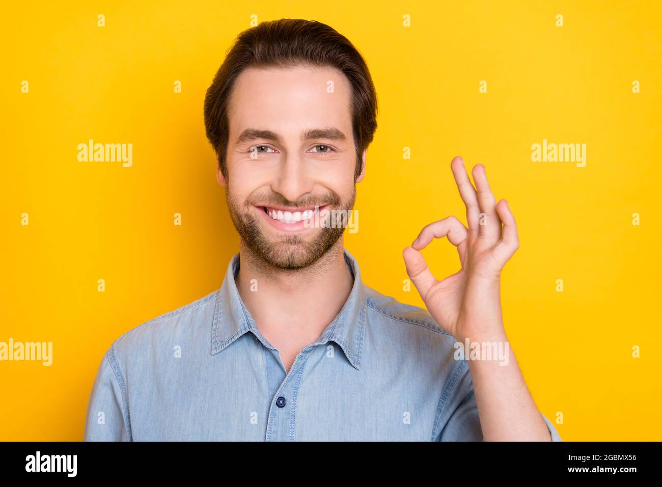 Photo portrait of young guy smiling showing okay gesture isolated on ...