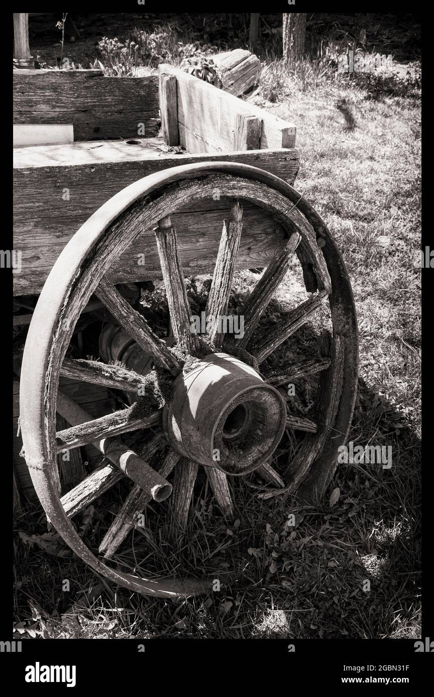 broken wagon wheel leaning against cart Stock Photo - Alamy