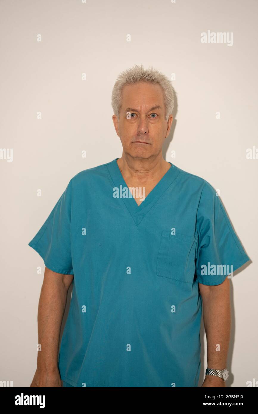 Mugshot style photo of a doctor or nurse against a white wall Stock ...