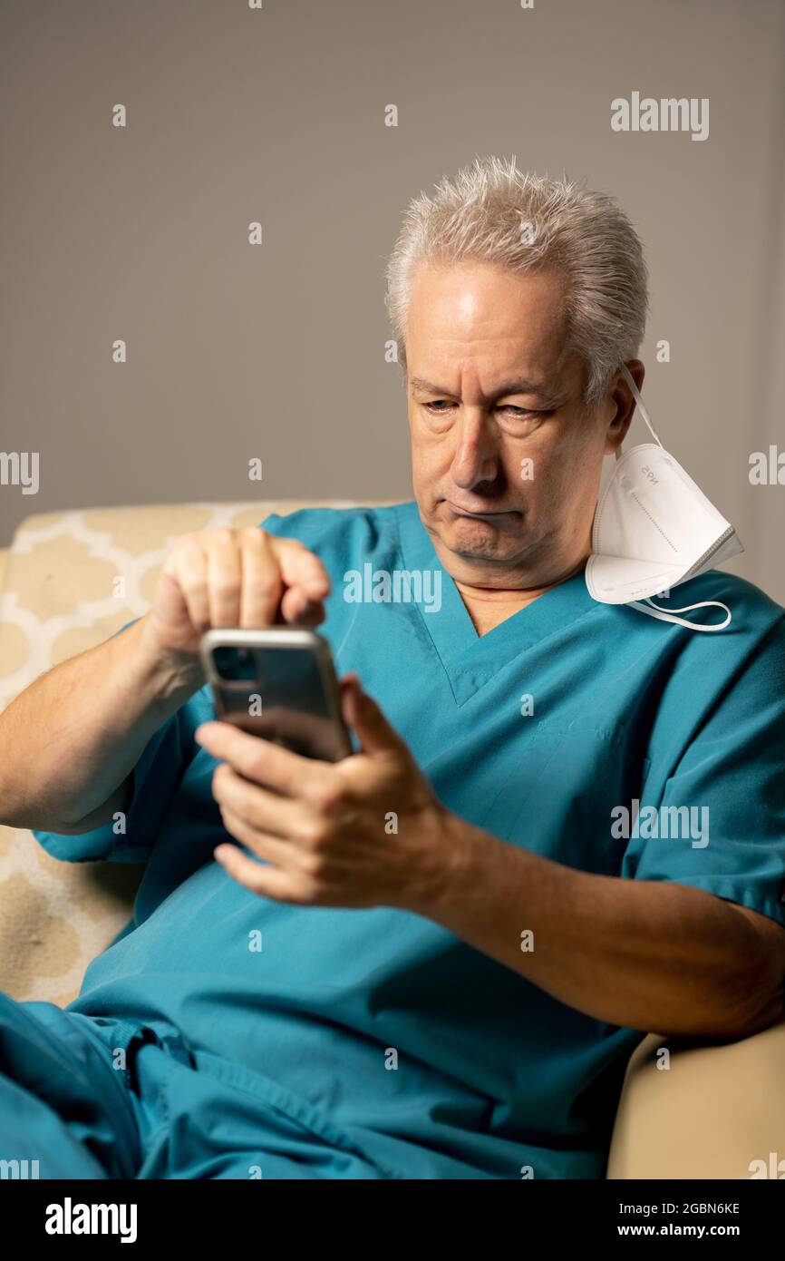Photo of a doctor or male nurse using a cellular smartphone Stock Photo ...