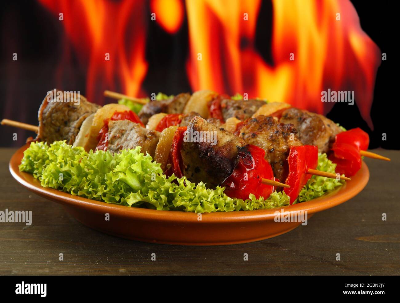 tasty grilled meat and vegetables on plate, on fire background Stock ...