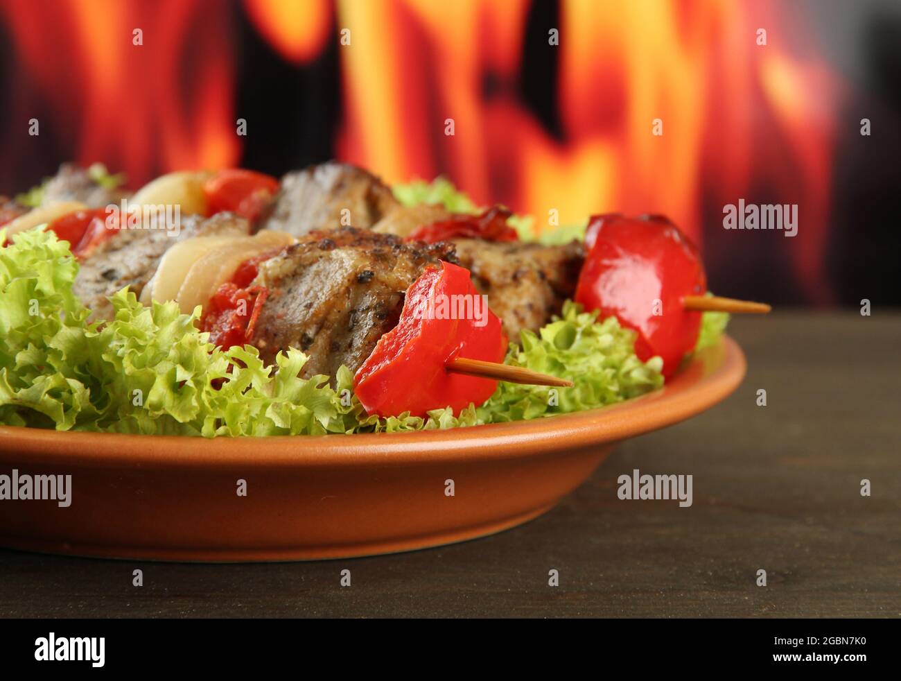 tasty grilled meat and vegetables on plate, on fire background Stock ...