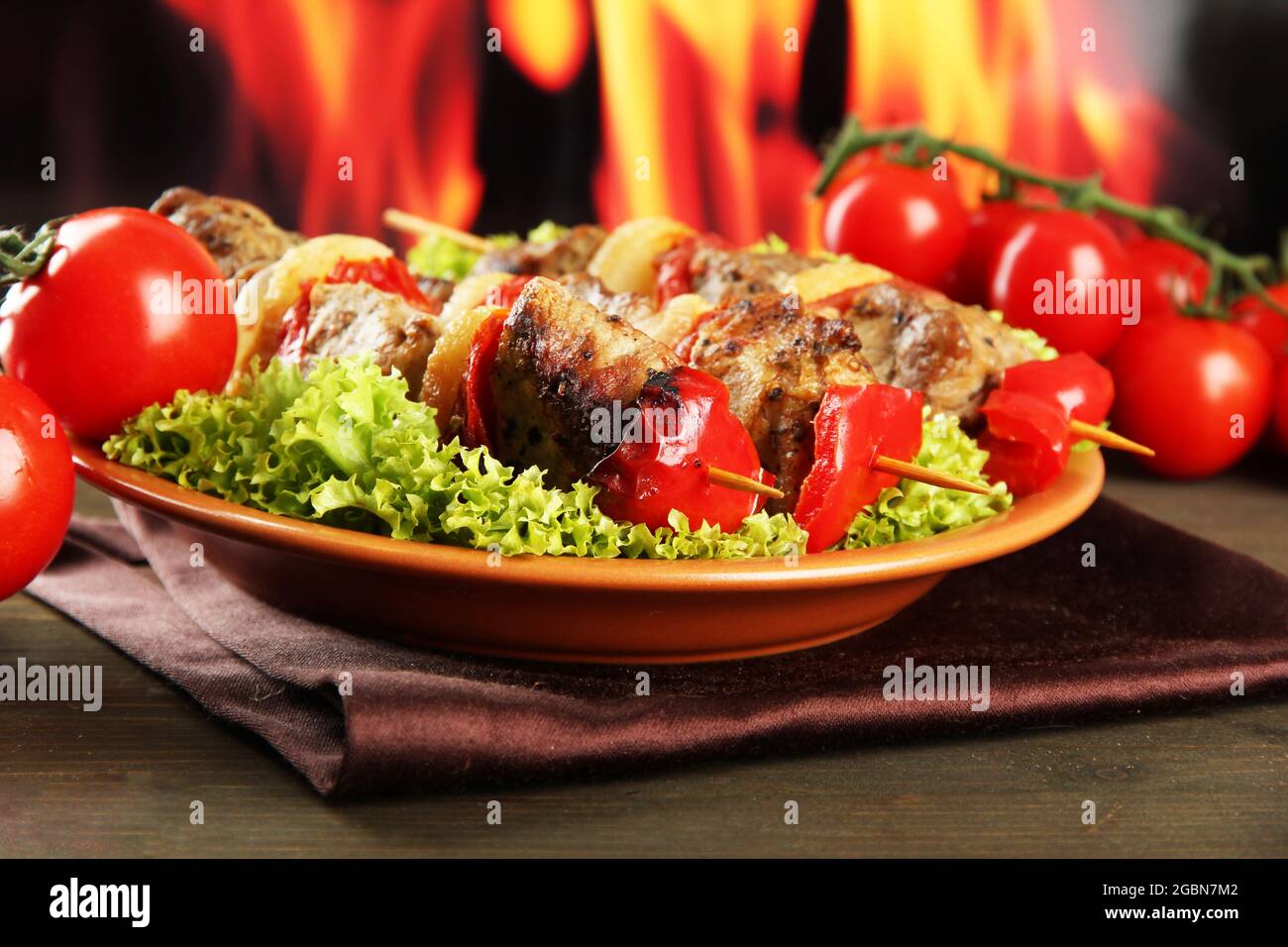tasty grilled meat and vegetables on plate, on fire background Stock ...
