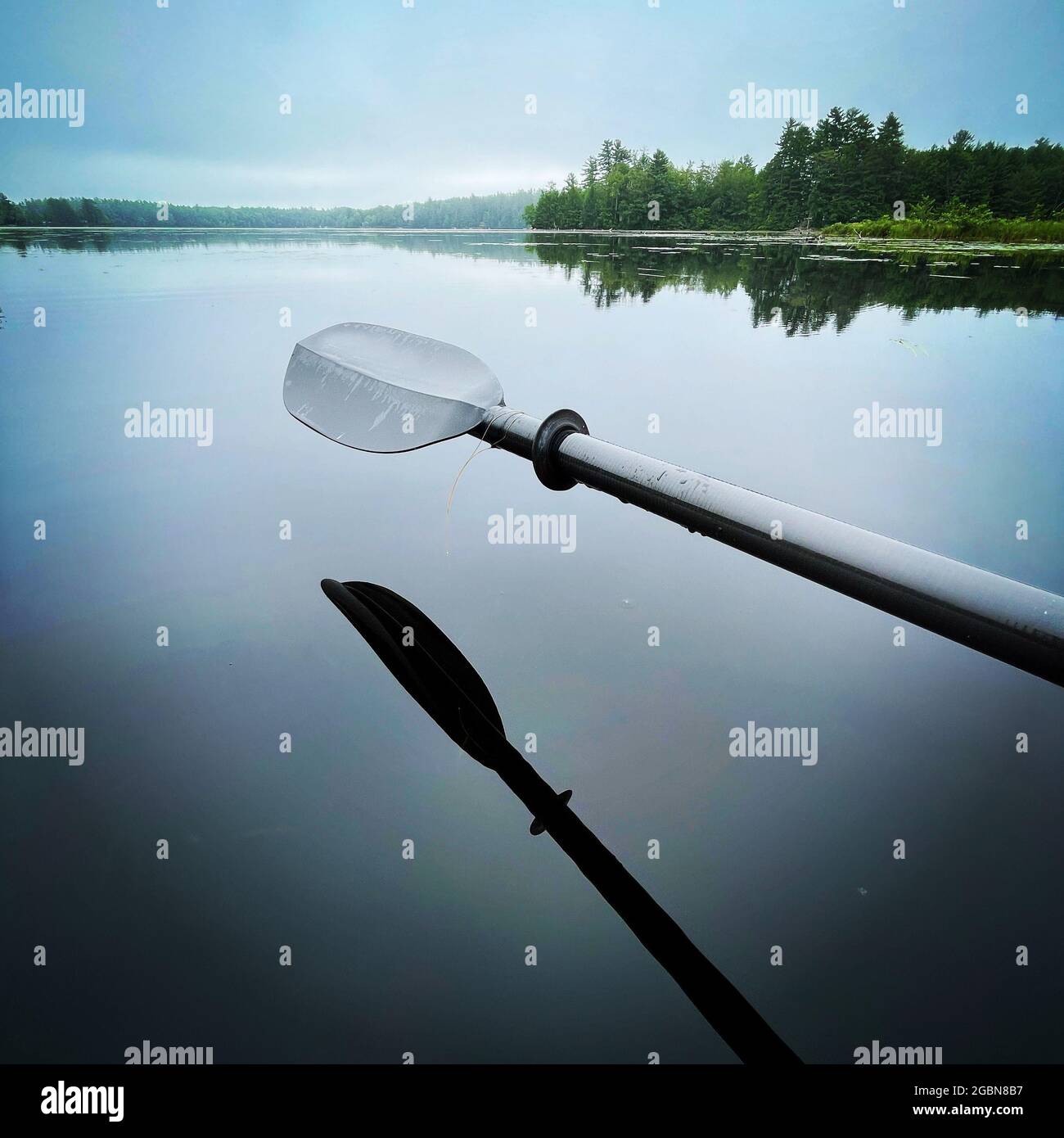 Kayak Paddle Reflection on Calm Lake Stock Photo - Alamy
