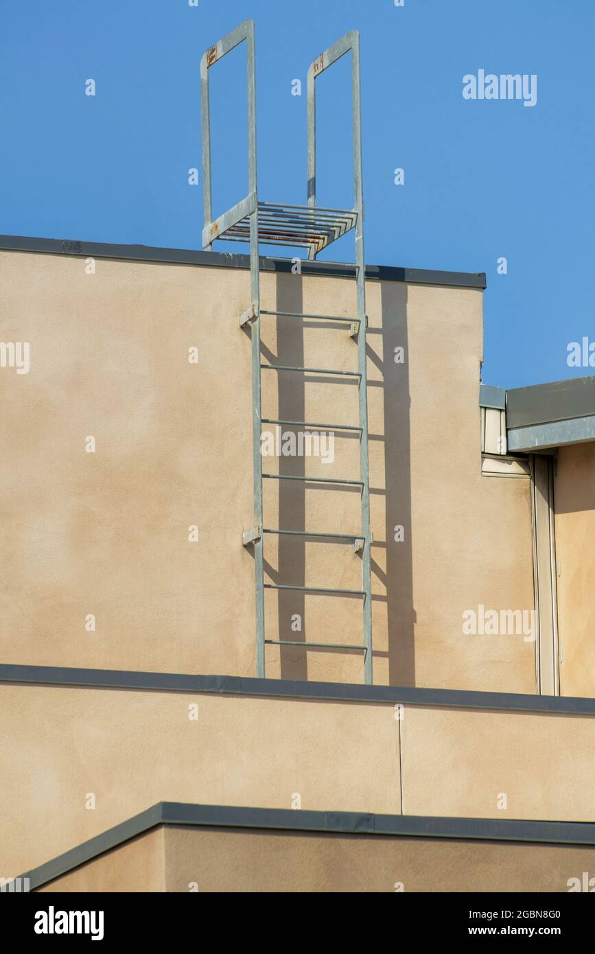 Vertical shot of an exit ladder of a building under a clear blue sky ...