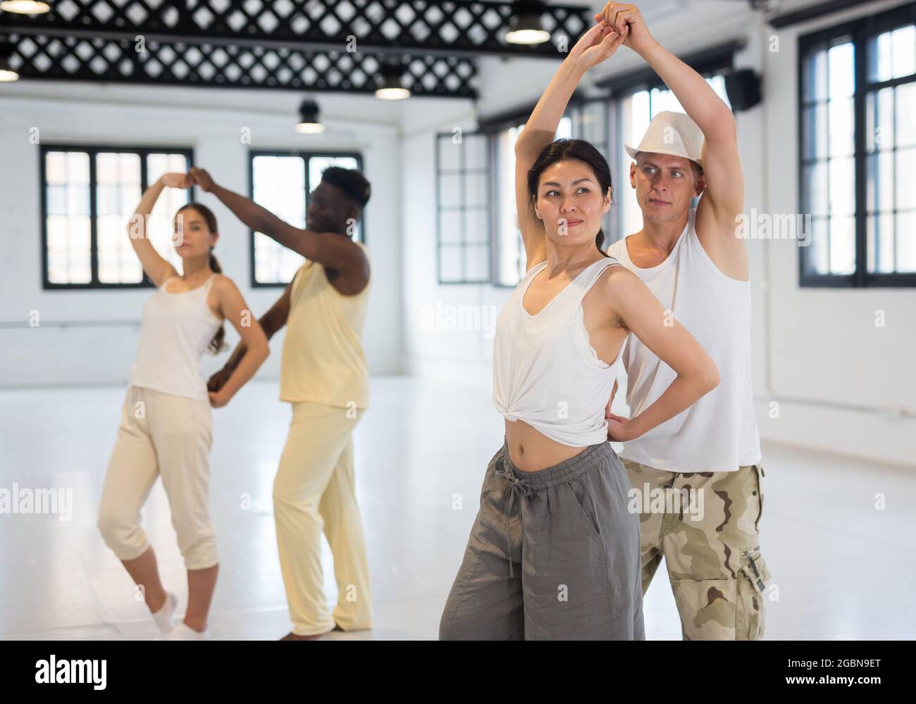 Group of men and women dancing salsa in dance studio Stock Photo - Alamy