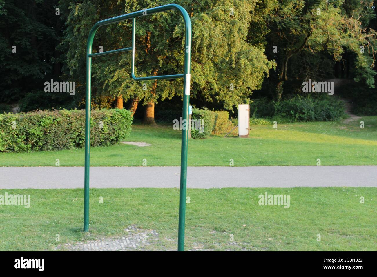 Green pull-up bar in a park covered in greenery unde the sunlight Stock ...