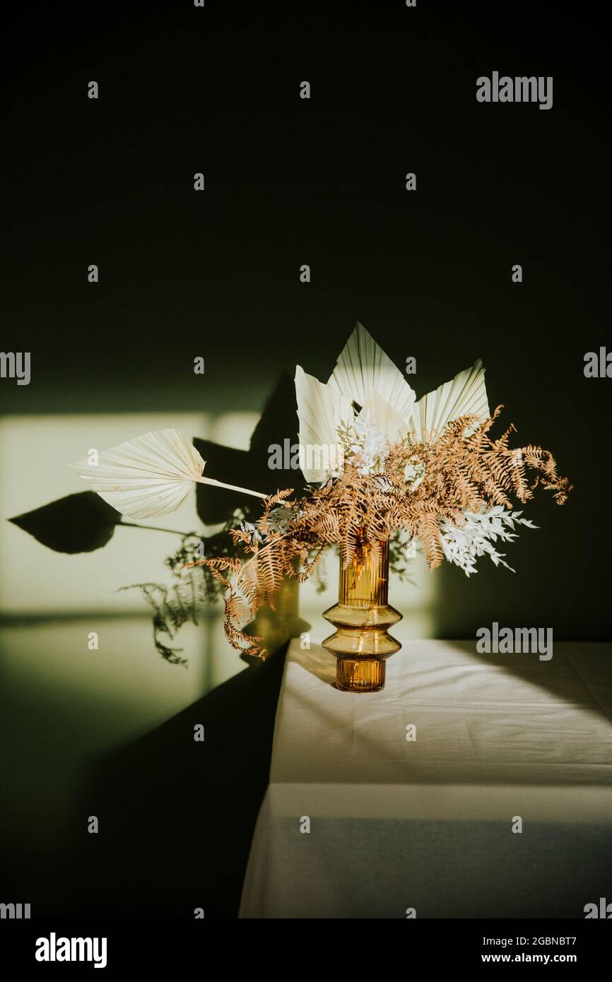 Flower vase with unique herbs and flowers on a table under the sunlight ...