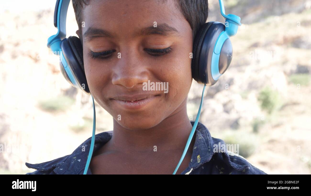 Cute happy kid in headphones standing outdoor Stock Photo - Alamy