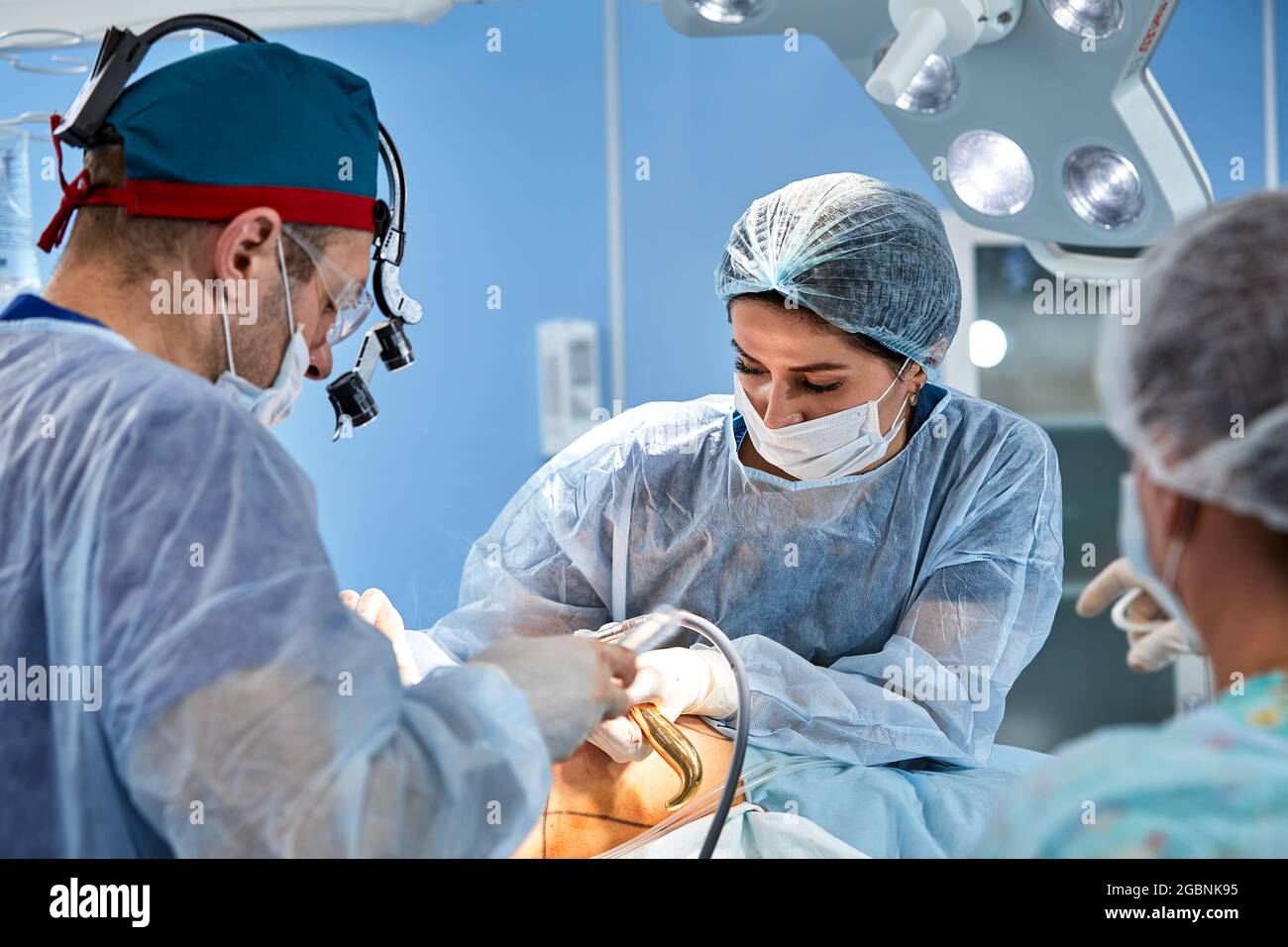 cosmetic liposuction surgery in actual operating room setting showing ...