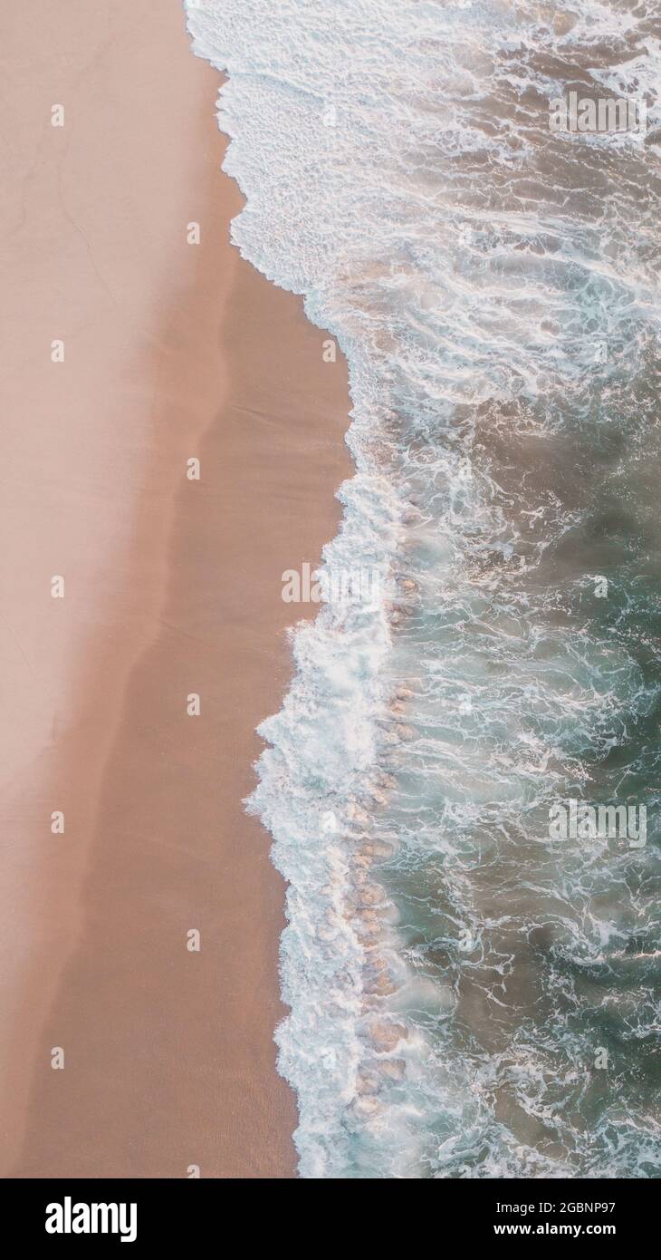 Overhead shot of oceanwater reaching a pink shore Stock Photo - Alamy