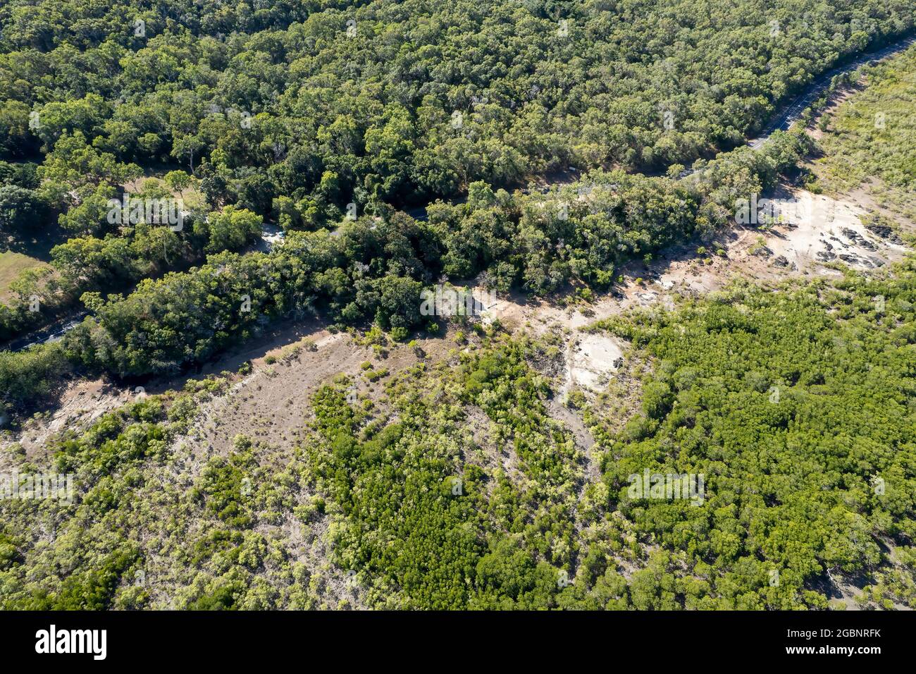 Aerial view over mangroves at low tide and beside a road on a tourist ...