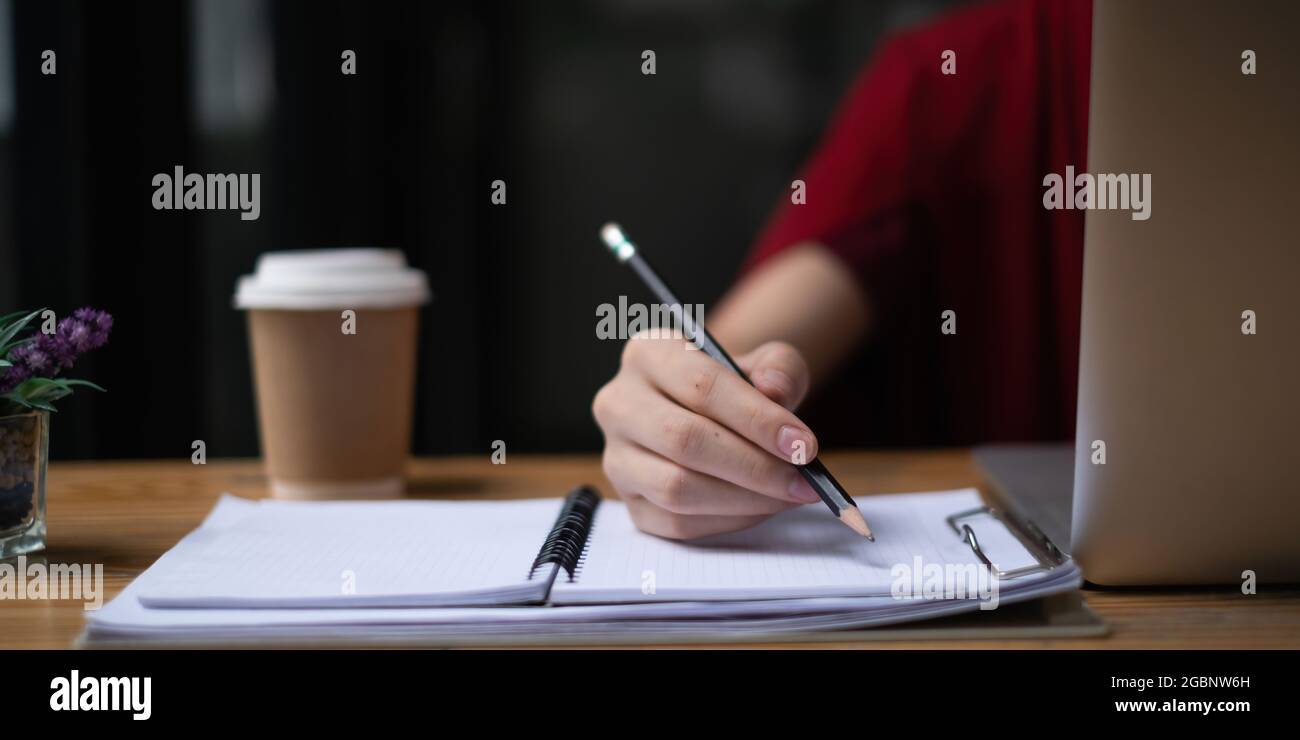 Young female college taking notes and using highlighter. Focused ...