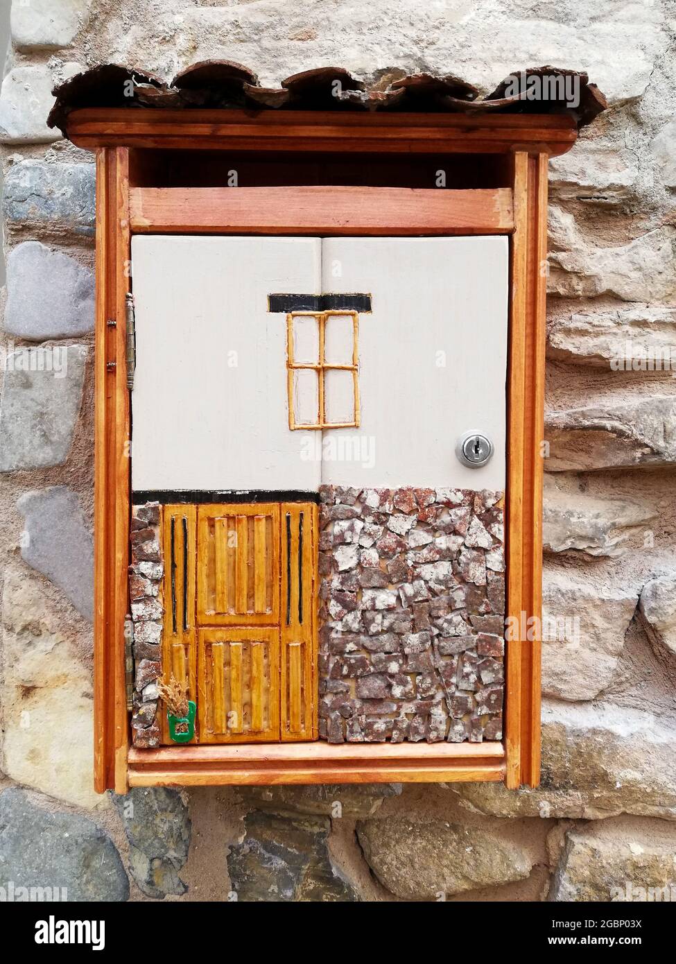 Closeup of a letterbox decorated with the drawing of a typical village ...