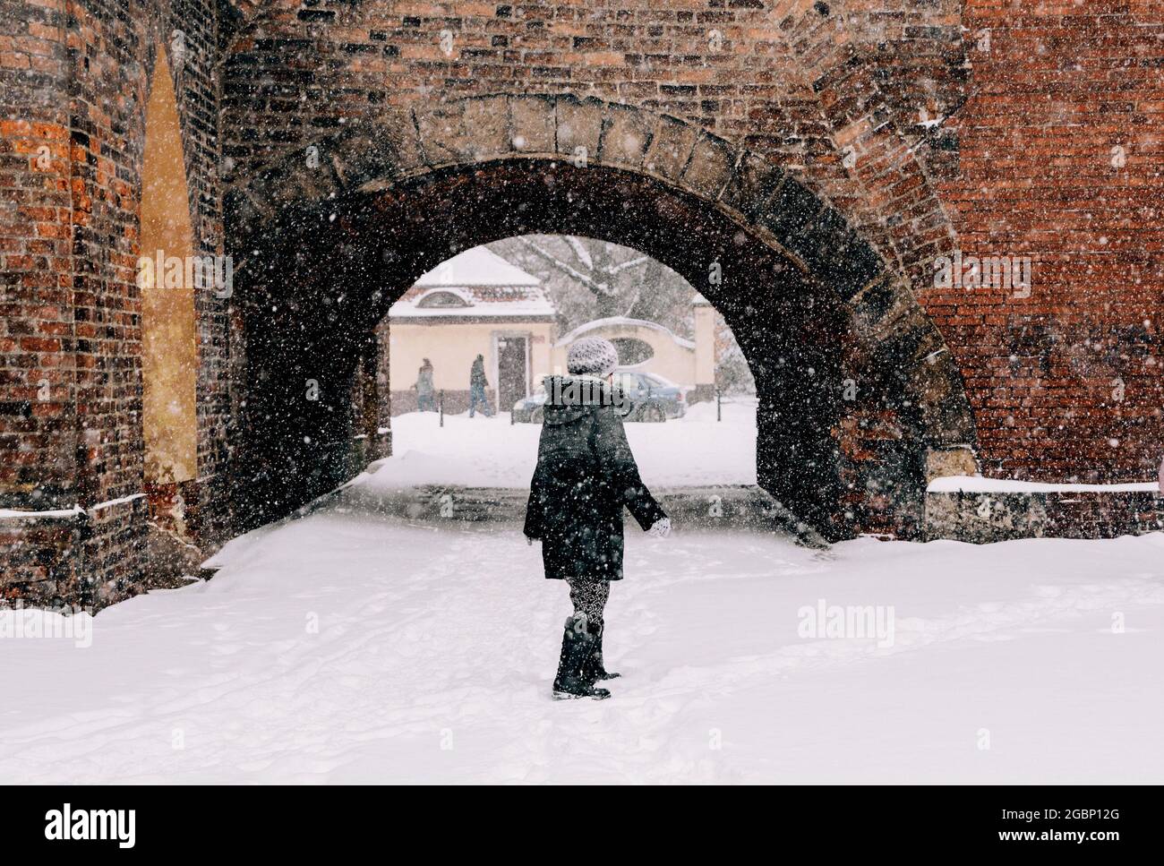 Girl standing near the arch bridge under the falling snow Stock Photo ...