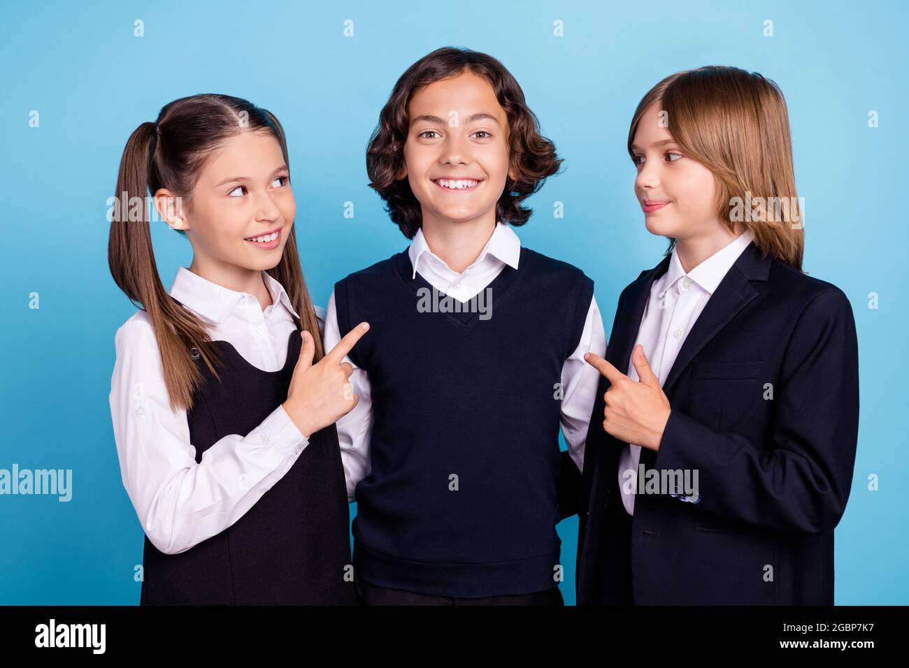 Photo portrait school mates smiling in uniform pointing finger on ...