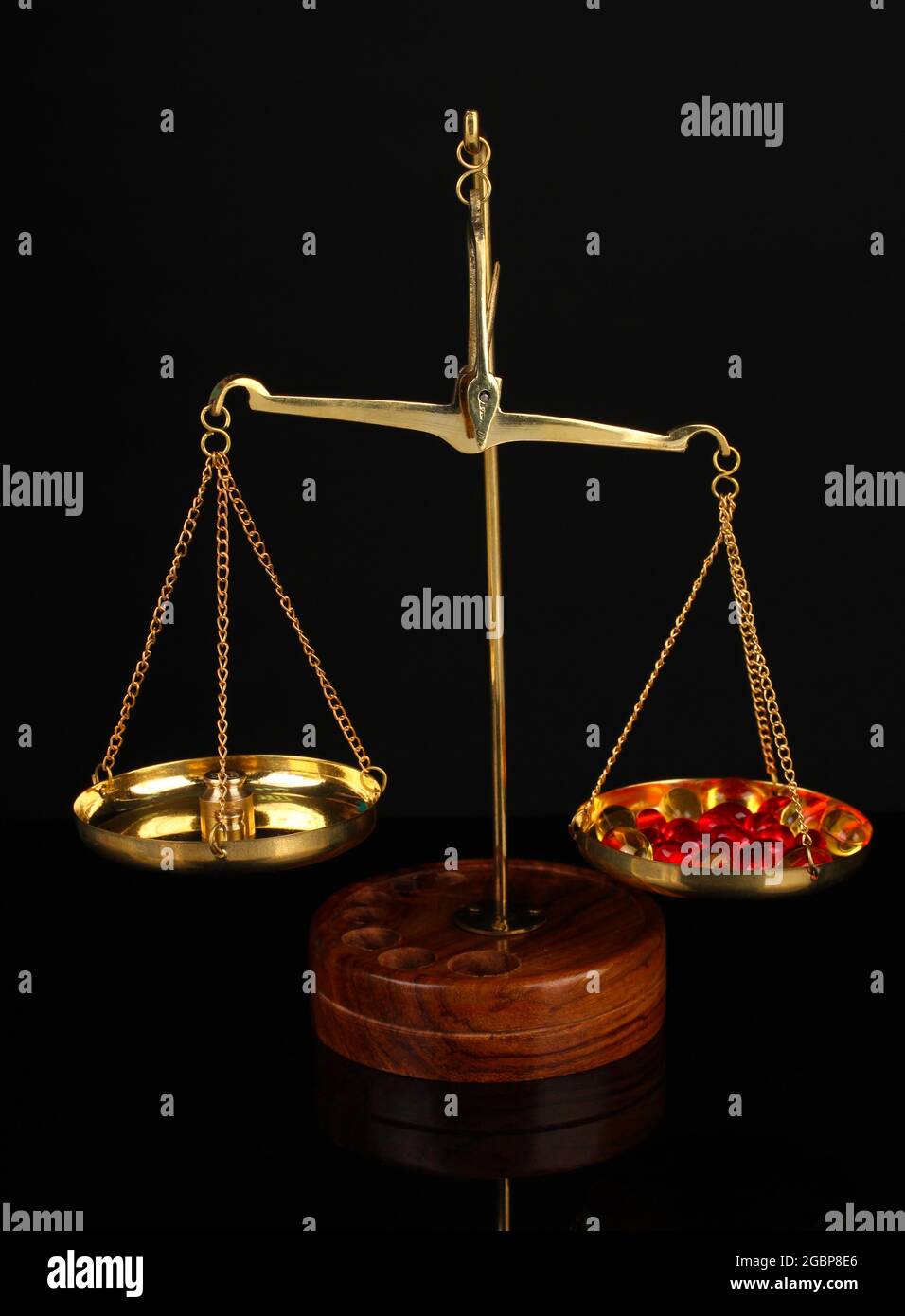 Classic scales with color pills isolated on black Stock Photo - Alamy