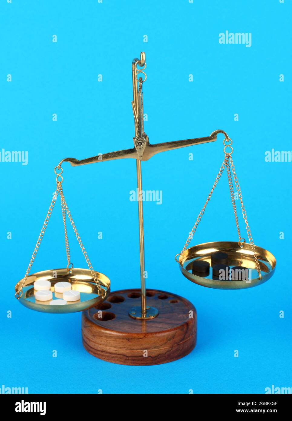 Classic scales with color pills on color background Stock Photo - Alamy