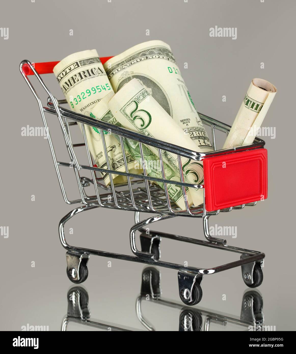 Money in cart on grey background Stock Photo - Alamy