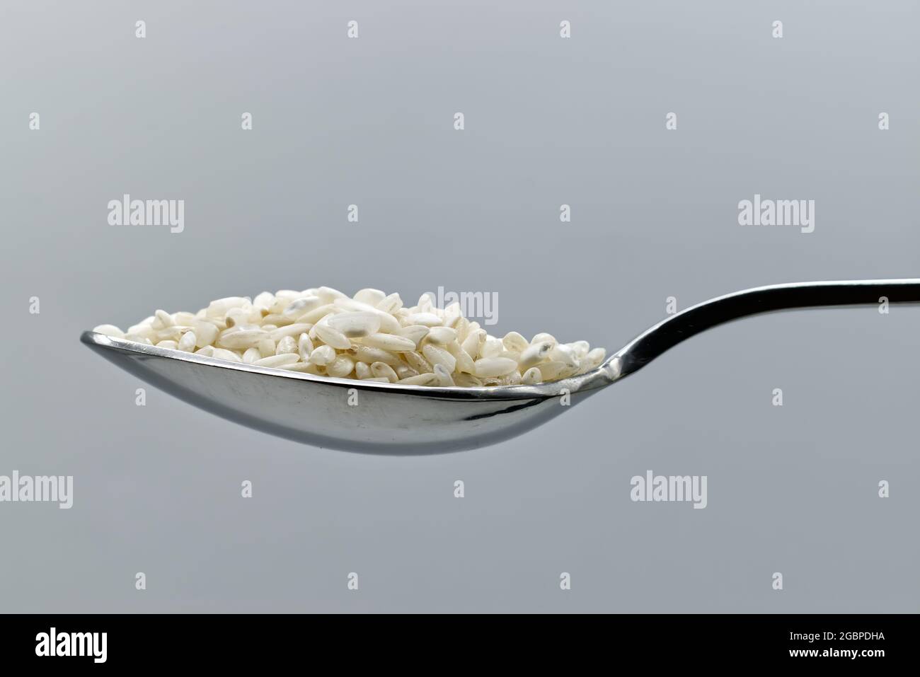 White Rice in a silver spoon isolated on white background Stock Photo ...