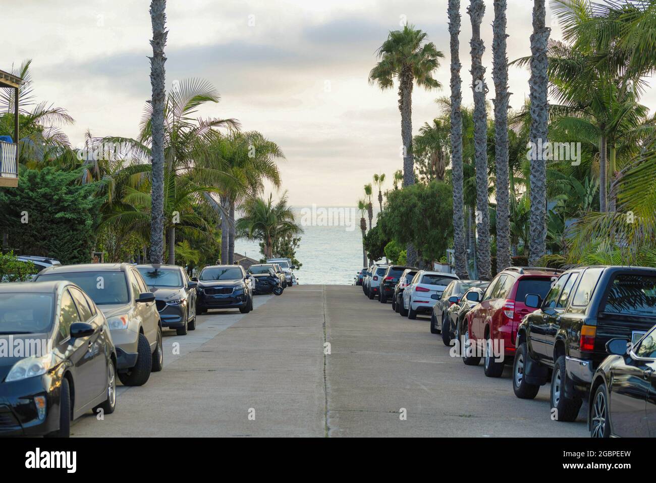 Scenic view of a straight asphalt road leaning to coast with cars ...