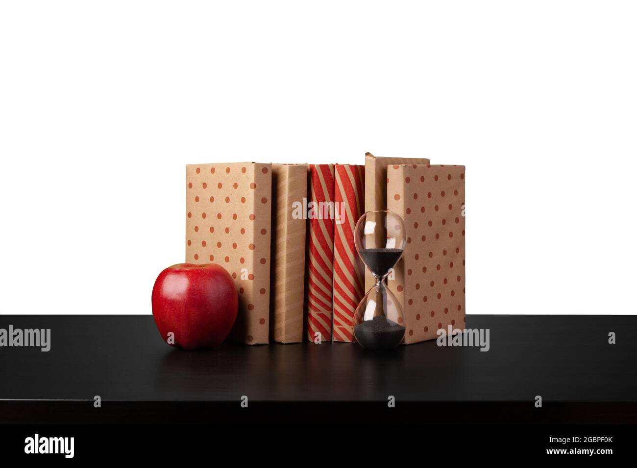 Stack of books and apple on tabletop against white background Stock ...