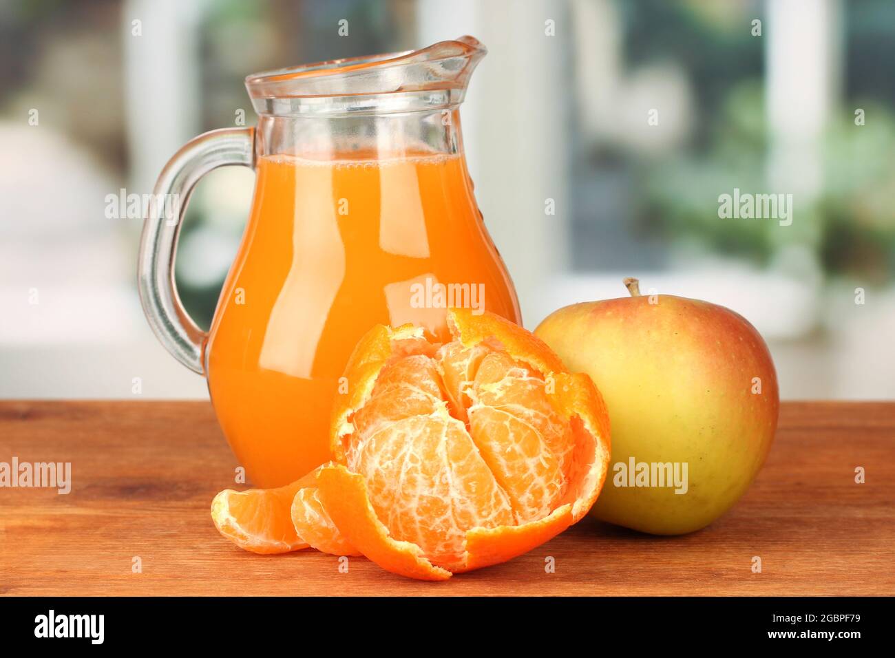 Full jug of multivitamin juice on bright background Stock Photo - Alamy