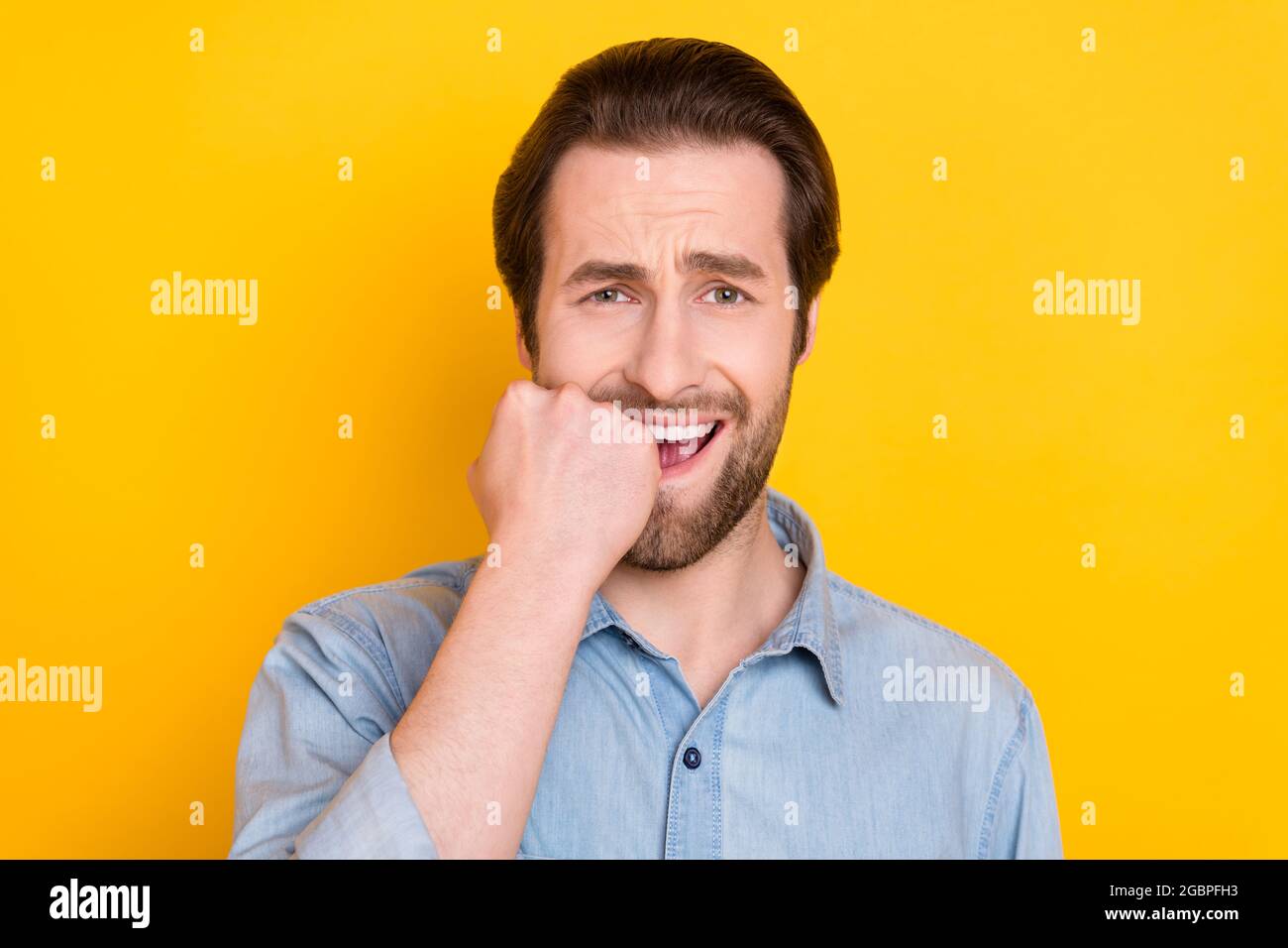 Photo portrait of young guy worried biting fist nervous isolated on ...