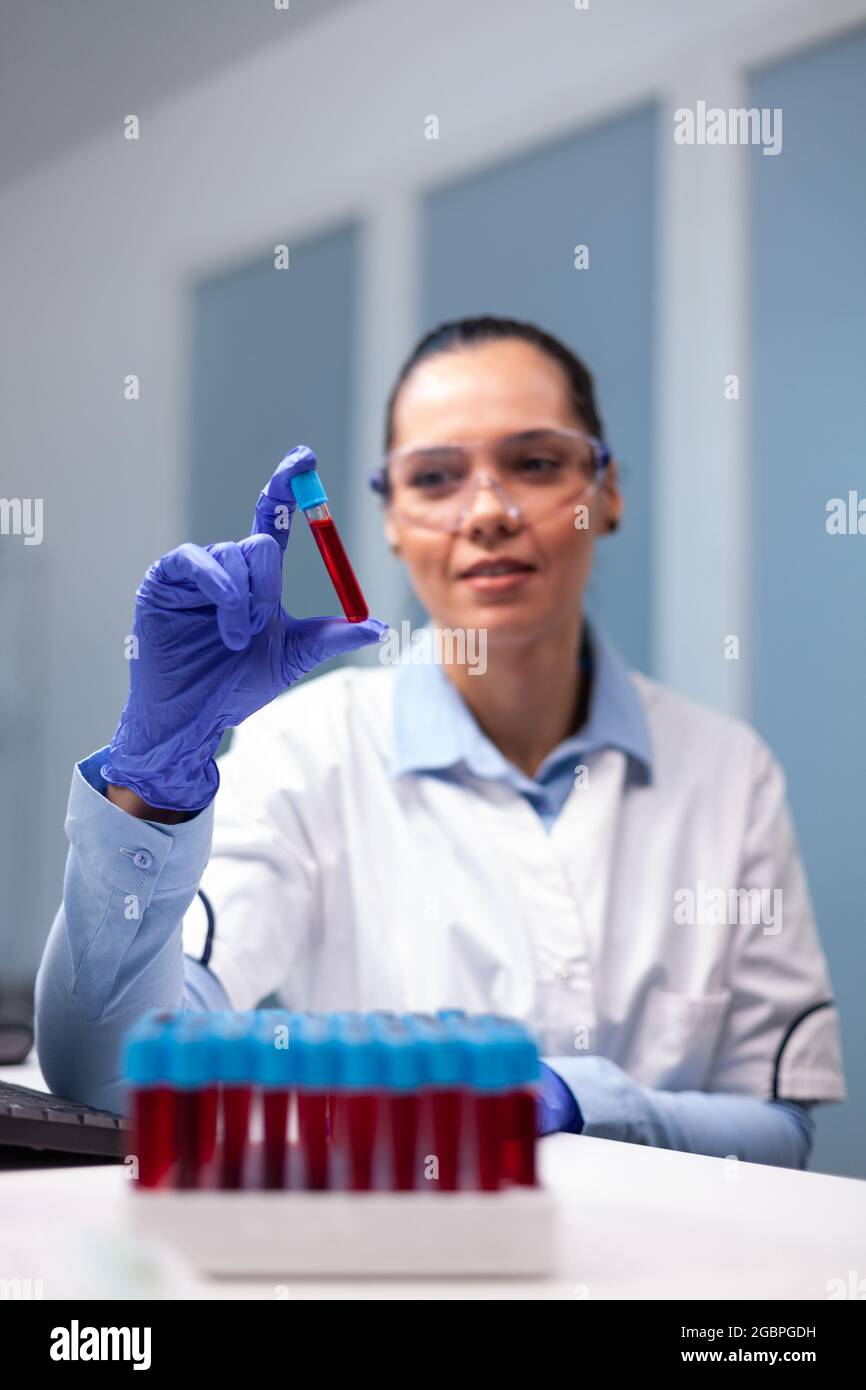 Chemist doctor analyzing dna blood using medical vacutainer working at ...