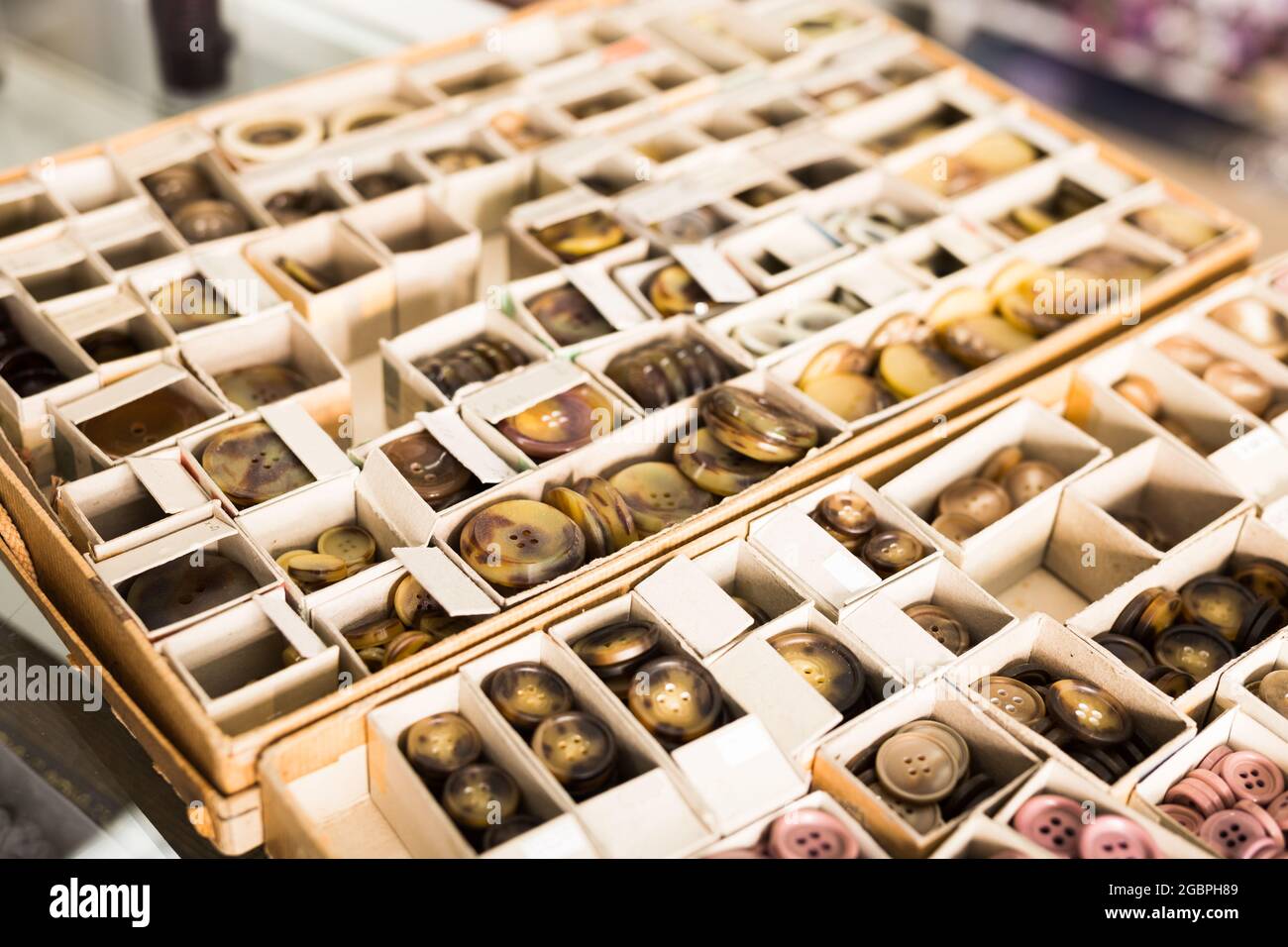 Buttons in carton on needlework store showcase Stock Photo - Alamy